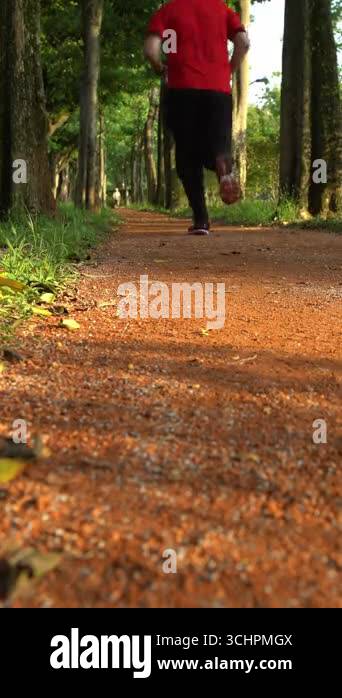 4K Road runner caucasian man running in Taipei city Daan park. Jogging ...