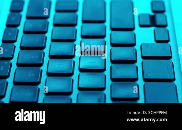This image shows a close up view of a keyboard with blue backlighting ...