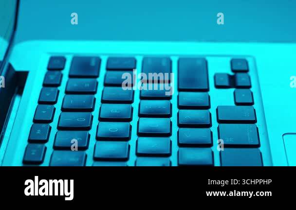 This image shows a close up view of a keyboard with blue backlighting ...