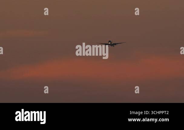 Footage of long shot dark silhouette airplane in picturesque sunset ...