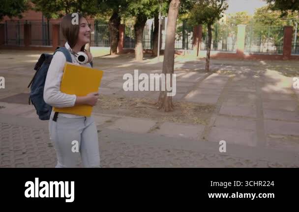 Female students sharing warm embrace outside school building ...