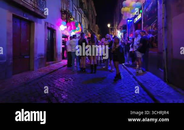 Lisbon Bairro Alto nightlife scene with bars, walking crowds, neon ...