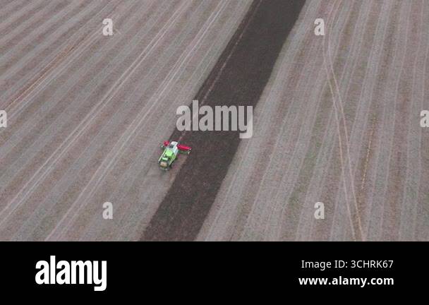 Motorcyclist racing on dirt track through fields captured by aerial ...