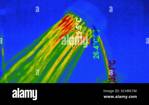 A thermographic camera shows hot water flowing from a shower head. The ...