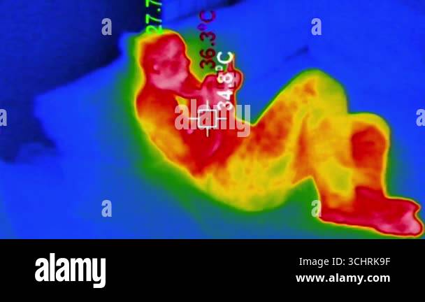 Thermal camera view of a person lying in bed while using a smartphone ...