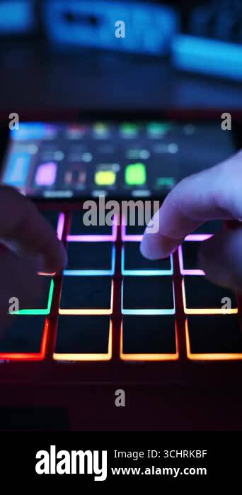 Two hands precisely press vibrant glowing pads on a red MIDI controller ...