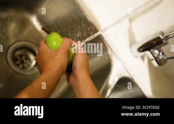 Hands washing a pear in a sink Stock Video Footage - Alamy