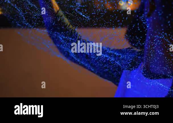 Man placing hands on console sparking blue particle wave passing ...