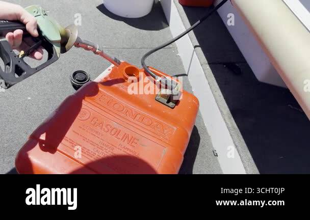 Gas spills from nozzle into container on boat Stock Video Footage - Alamy