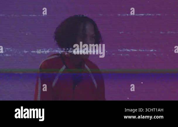 Mid adult woman turning head, grabbing sports ball while extending arm ...