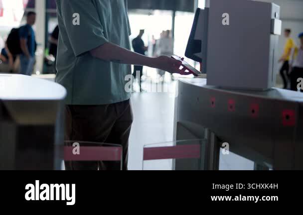 Passengers using smartphone nfc technology to pass through turnstiles in a busy transportation ...