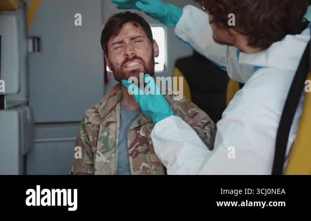 Medic treating wounds of injured soldier suffering in pain. Footage of ...