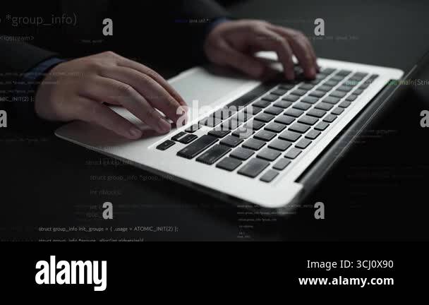 A close-up view of hands typing on a laptop keyboard, immersed in a ...