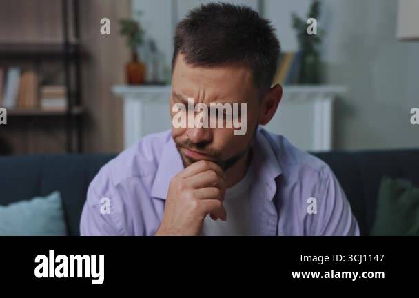 Portrait handsome exhausted sad young man bearded sitting alone on the ...