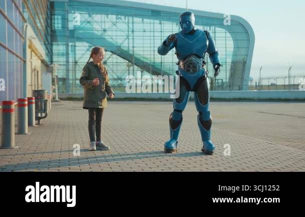 Funny girl dancing with humanoid robot cyborg smiling on street ...