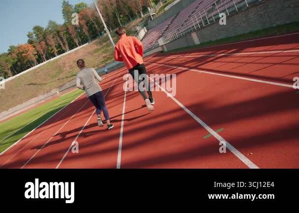 Team couple male and female runners performing cardio running activity ...