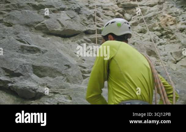 Young bearded handsome climber guy climbing mountain cliff stone rock ...