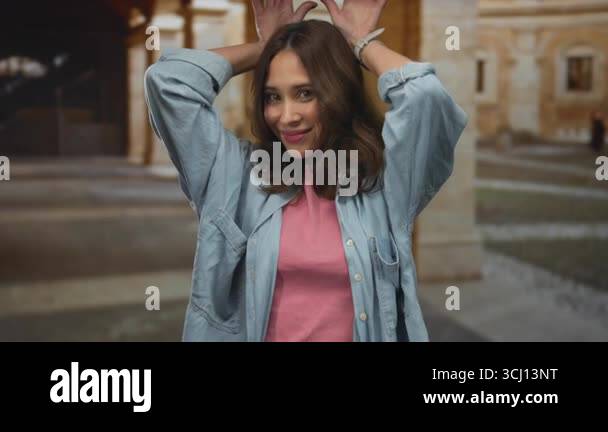 Woman making playful gestures inside an old university building ...