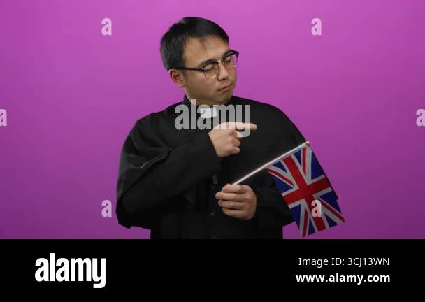 Priest man holding uk flag against pink background, wearing glasses ...