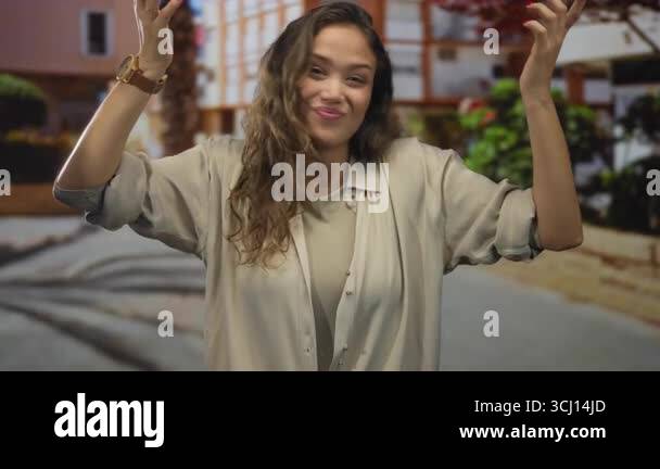 Woman pointing finger down at an outdoor urban street scene with ...