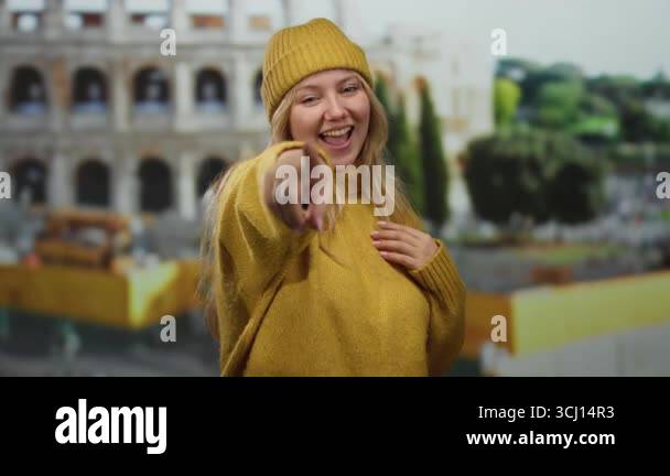 Woman smiling in front of the roman coliseum wearing a yellow sweater ...