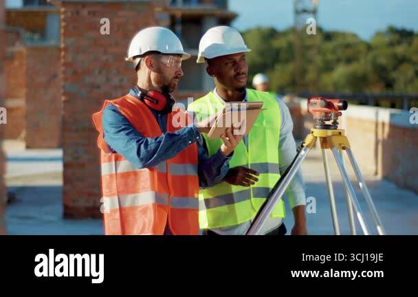 At sunlight two men engineers surveyor take measures with theodolite ...