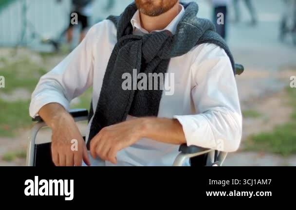 At sunlight portrait handsome disabled man in wheelchairat look at ...