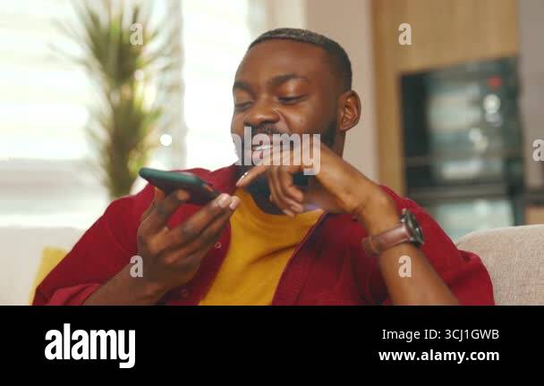 Happy african american young man recording voice message use phone in ...