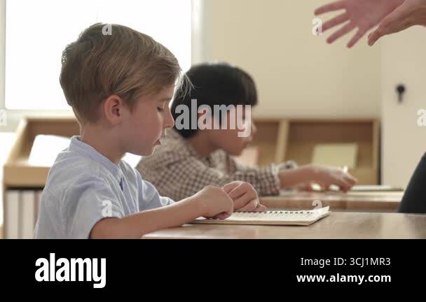 Side view of caucasian elementary student looking a note and answer ...