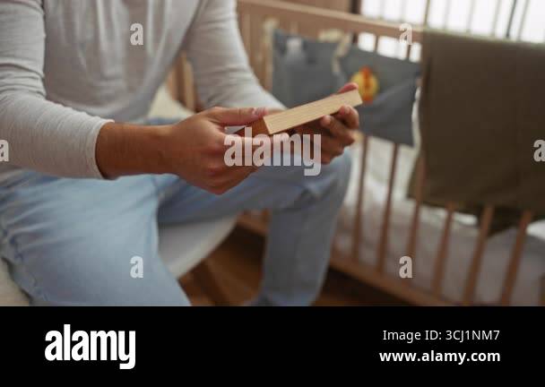 Young man sitting on a bed in a cozy bedroom holding a picture frame ...