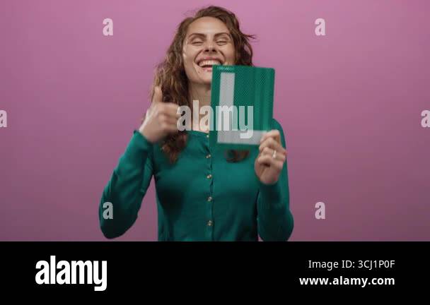 Woman smiling and holding a green learner sign against an isolated pink ...