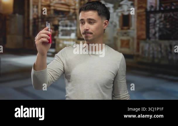 Man indoors examining vape pen in a church setting with thoughtful ...