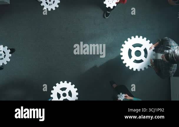 Top down aerial view of business team working together to gather cog ...