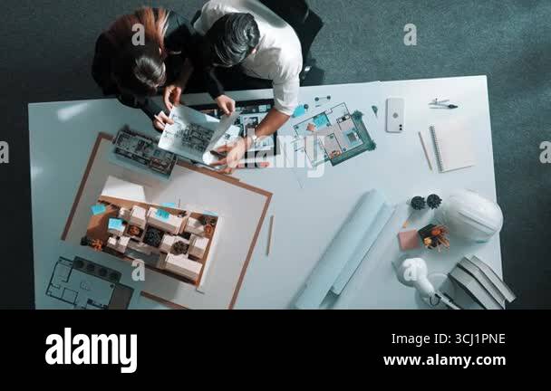 Top view of architect engineer sitting while explain house plan to ...