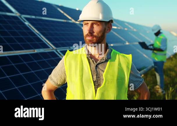 Attractive young worker man stand look at camera near solar batteries ...