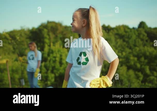 Portrait cute smiling little girl helping environment look at camera ...