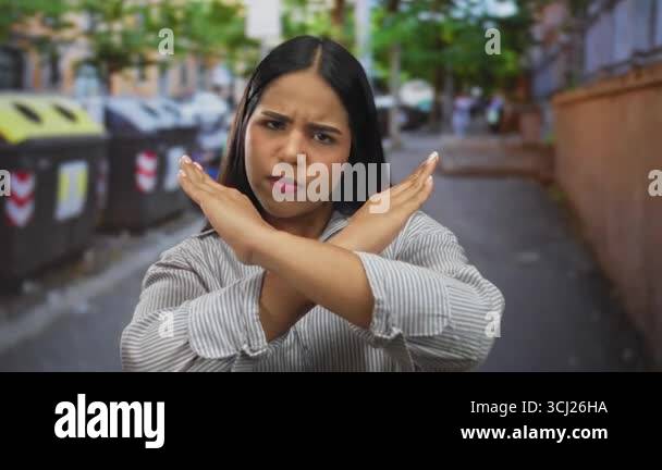 Woman expressing disapproval with crossed arms on urban street ...