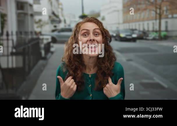 Young woman with curly hair in green sweater expressing emotions on a ...