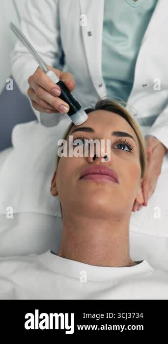 Professional beautician performing an ultrasound cavitation procedure ...