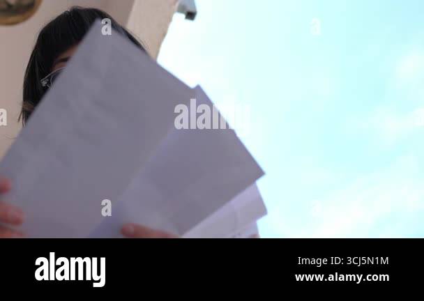 Portrait of white woman holding stack of letters in hands near letter ...