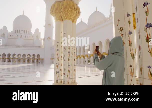 A female tourist captures the beauty of the Sheikh Zayed Grand Mosque ...