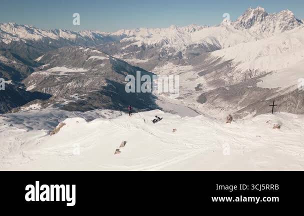 Aerial view Freeriders on snowy ridge under clear blue sky, symbolizing ...