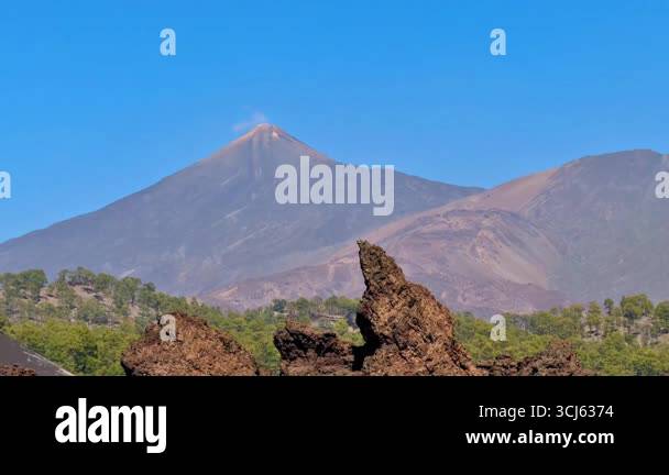 A stunning view of an active volcano framed by rocky terrain and ...