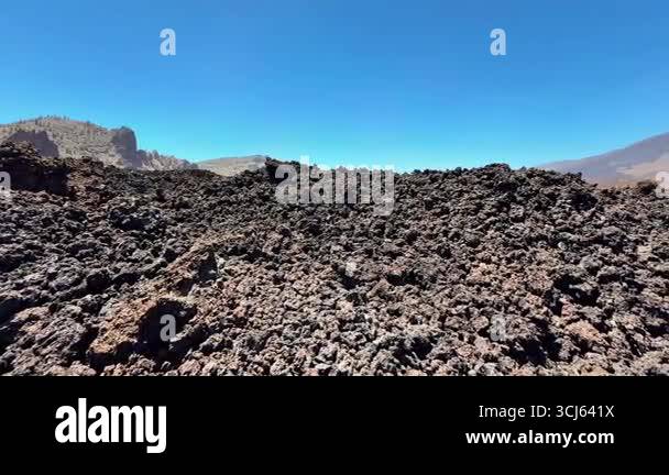 A stunning volcanic lava field features rugged rocks against a clear ...
