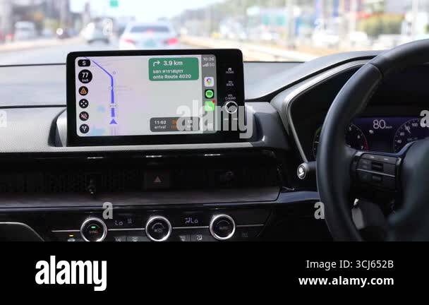 Interior car view with GPS navigation on display, driving through Phuket. Bright daylight ...