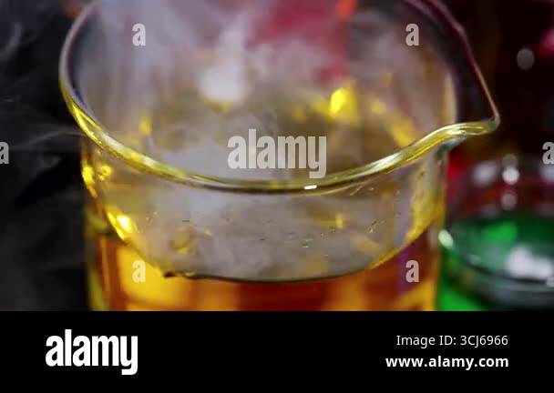 Dry ice reacts in beaker, producing smoke Stock Video Footage - Alamy