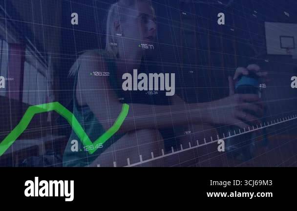 Female athlete sitting in gym responding to animated chart changes and drinking water for ...