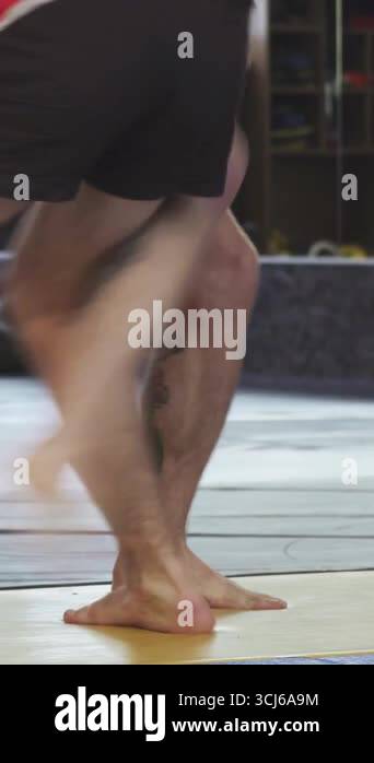 In a dynamic gym setting, a focused male MMA fighter skillfully applies ...