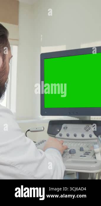 A joyful male doctor expertly navigates an ultrasound scanner, his ...