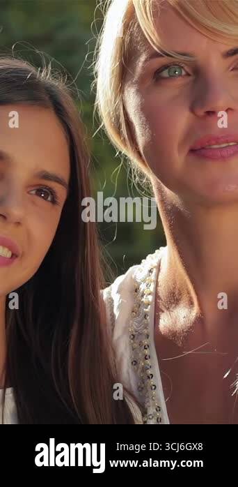 A joyful mother and her teenage daughter share a tender kiss, their ...